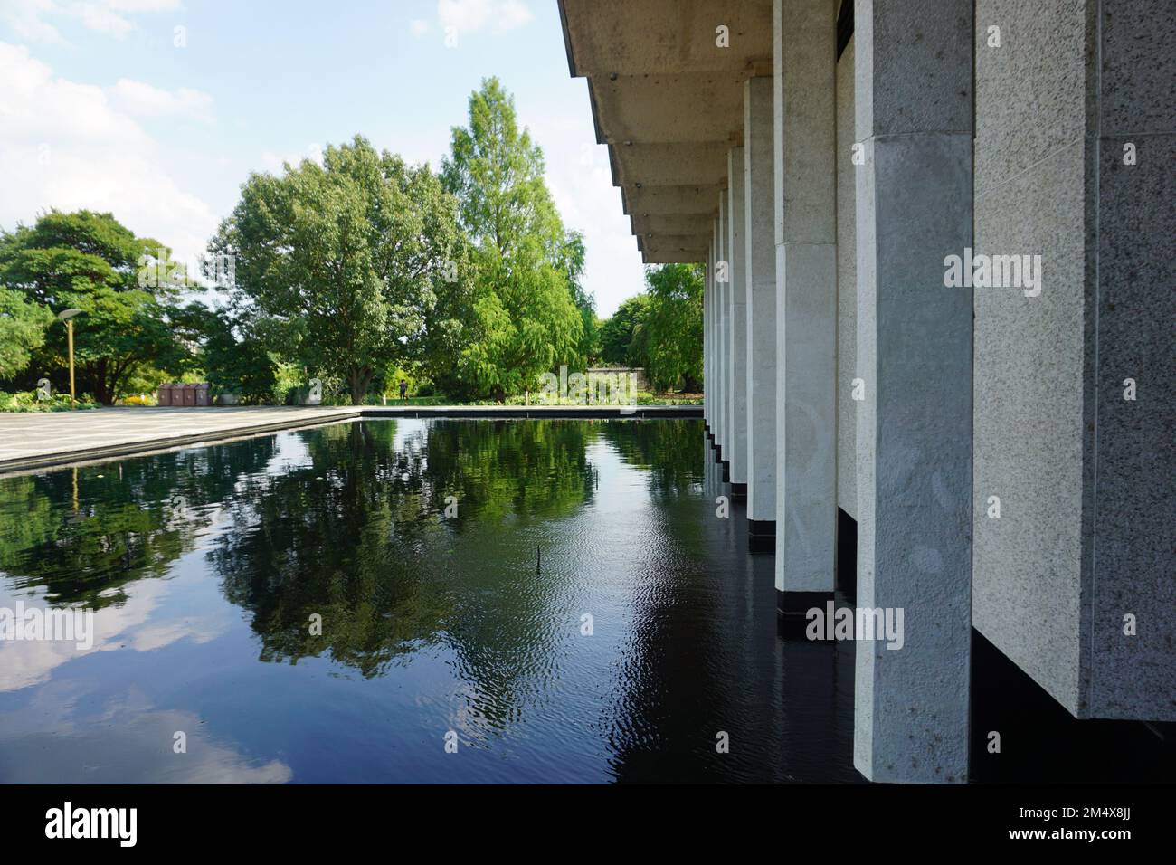 Reflecting pool outside building with pillar Stock Photo - Alamy