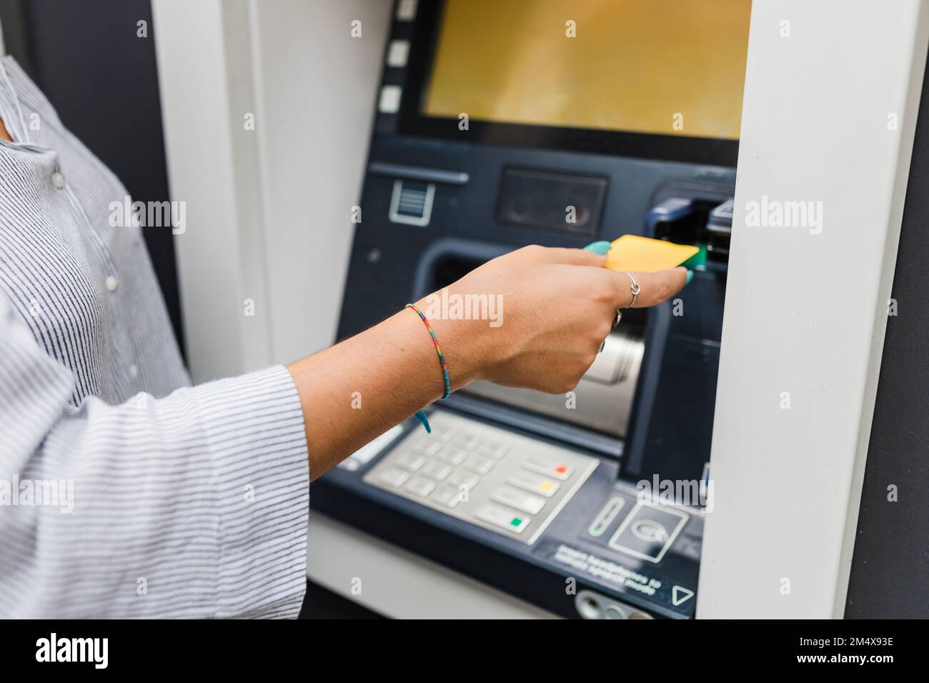 Hand of woman inserting credit card in ATM machine Stock Photo - Alamy