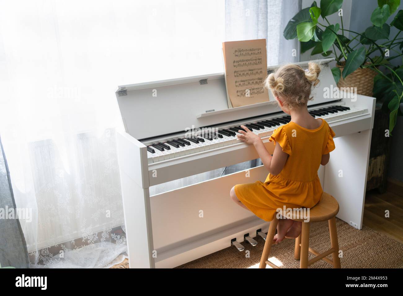 Girl practicing piano at home Stock Photo - Alamy