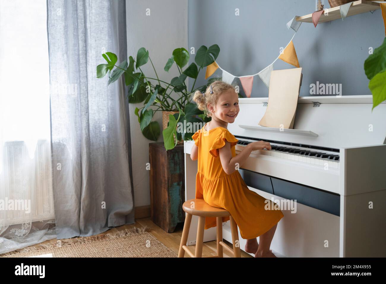 Girl playing piano looking camera hi-res stock photography and images ...