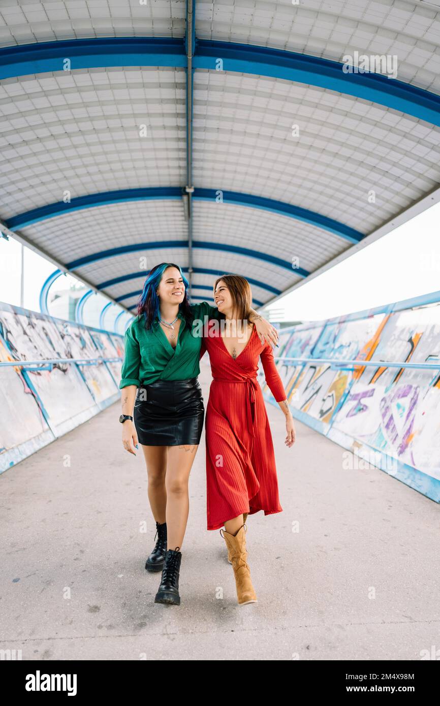 Two young women walking arm hi-res stock photography and images - Alamy