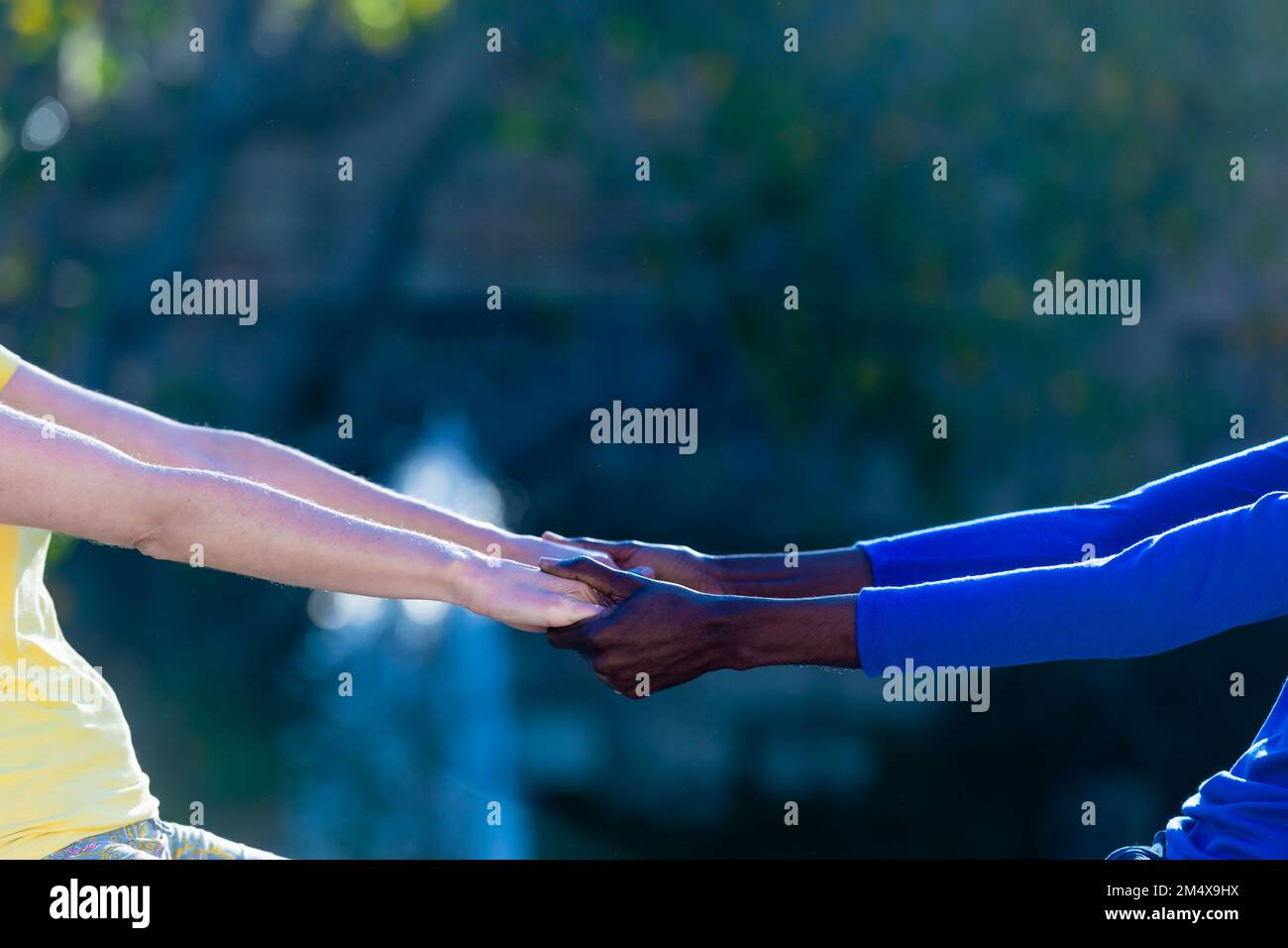 Multiracial couple holding hands of each other Stock Photo - Alamy