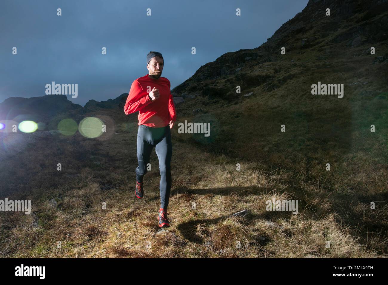 Man running on hill at dusk Stock Photo - Alamy