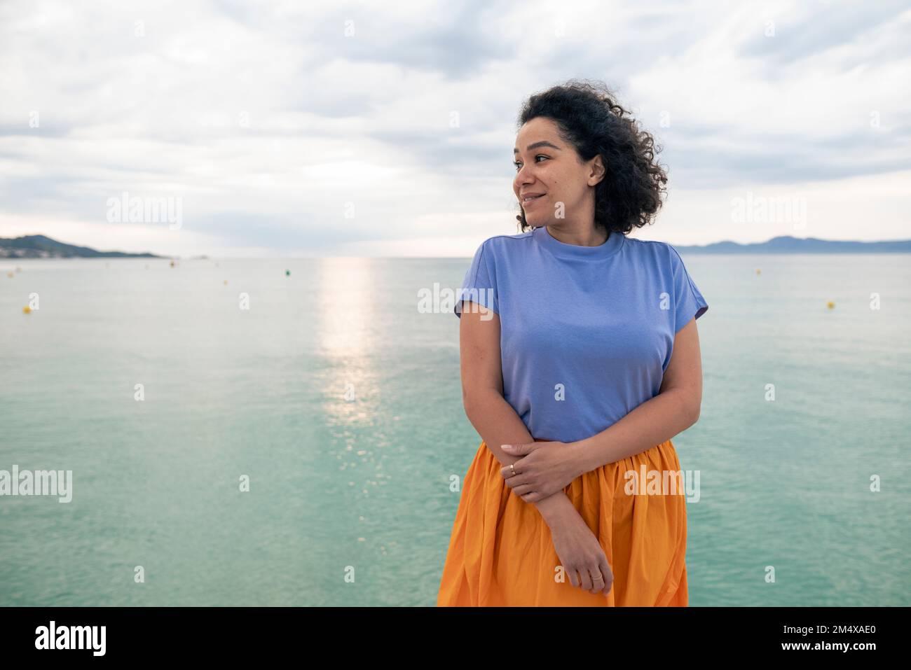 Contemplative woman standing in front of sea Stock Photo - Alamy
