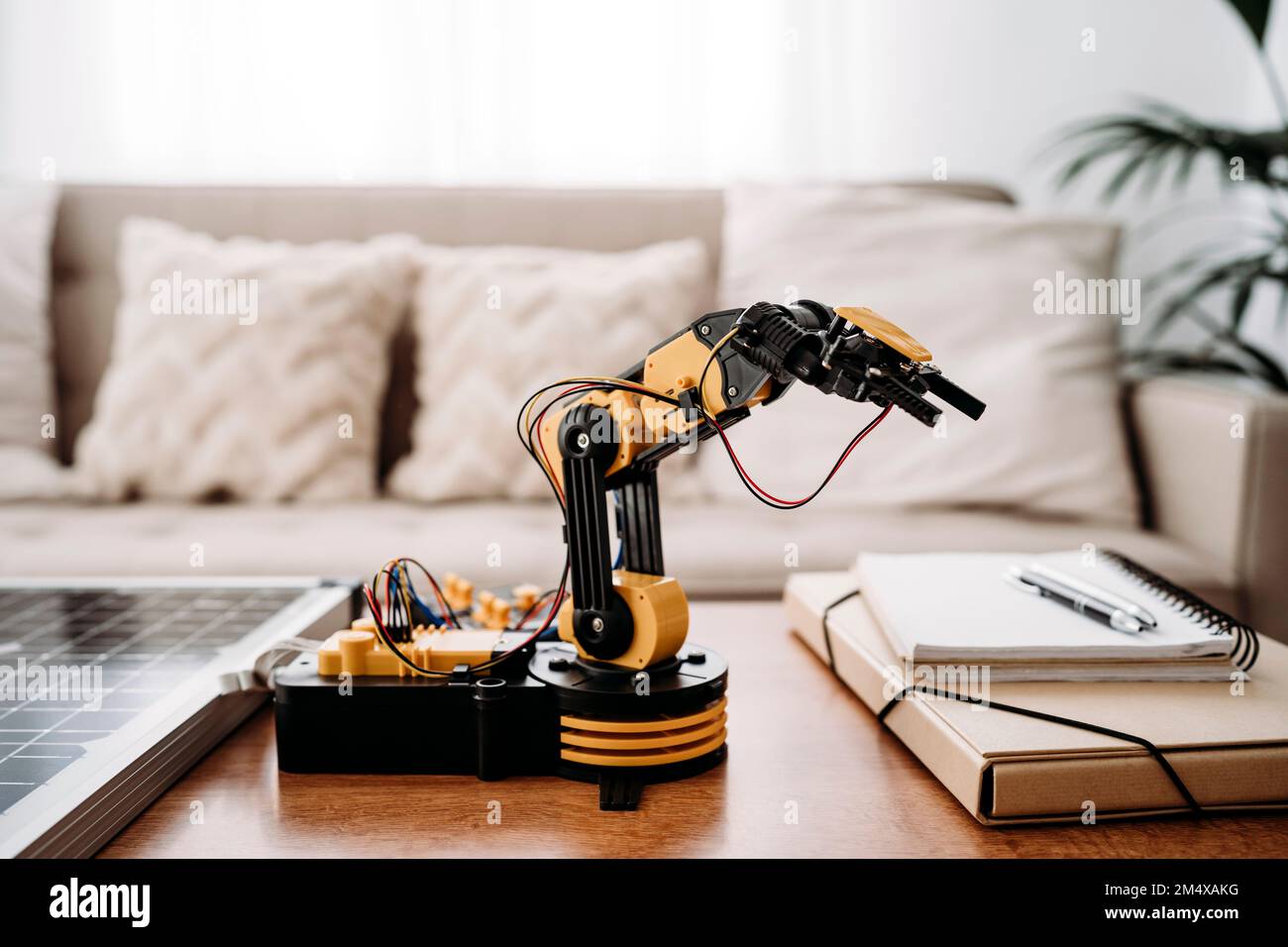 Robotic arm amidst solar panel and diary on table at home Stock Photo ...