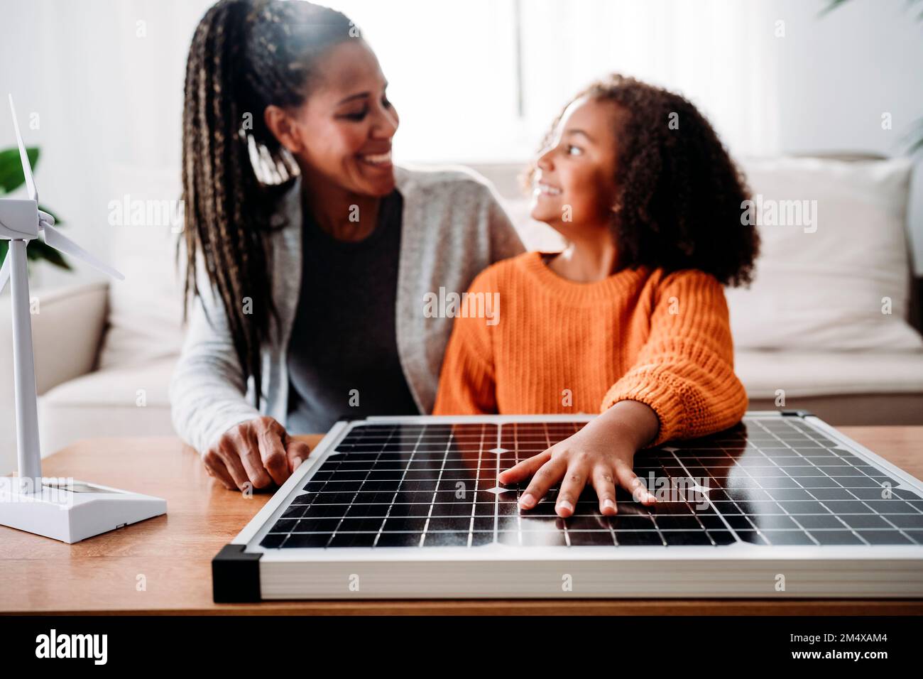 Happy mother and daughter with solar panel at home Stock Photo - Alamy