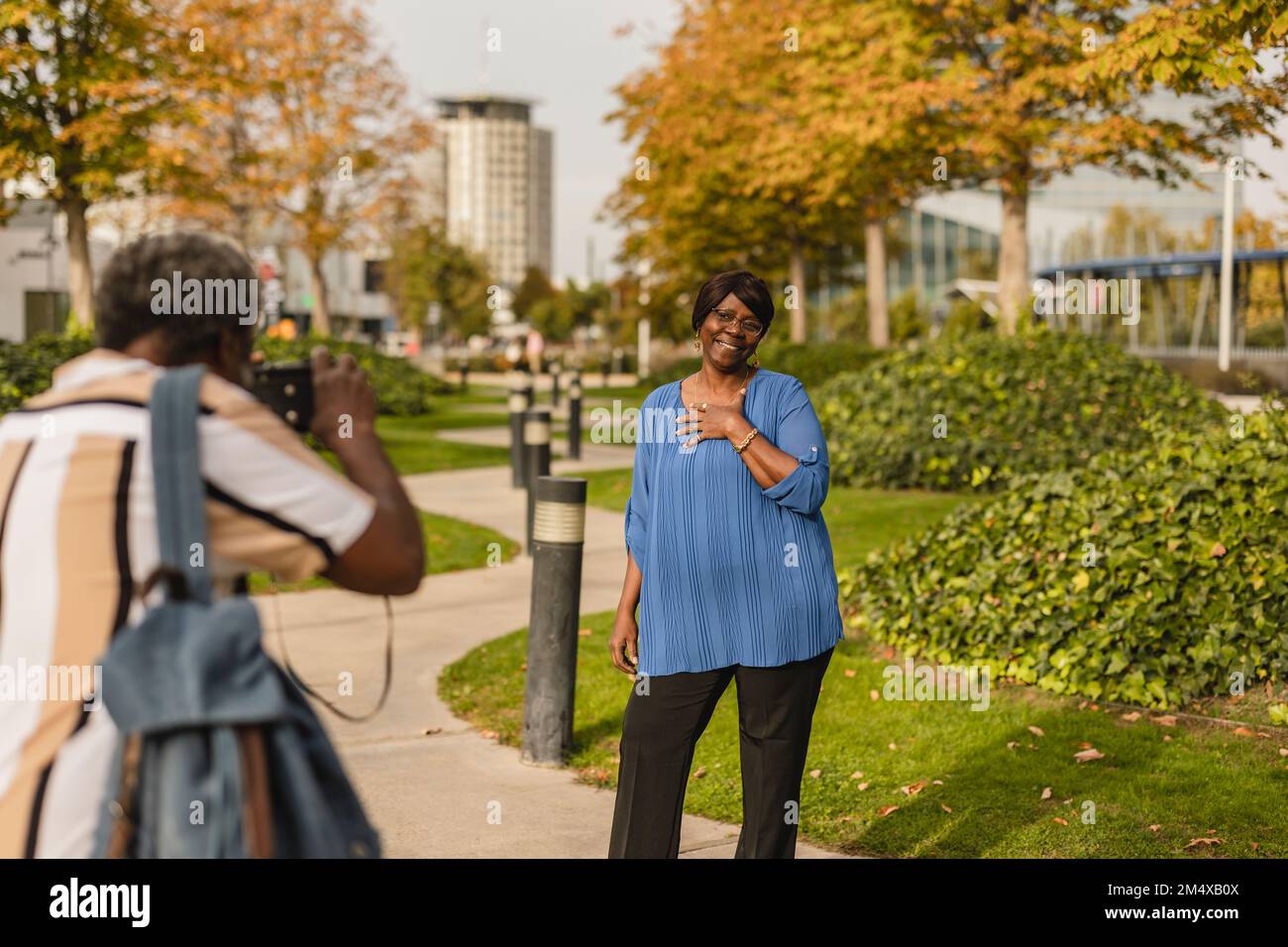 Man photographing woman through camera standing in park Stock Photo - Alamy