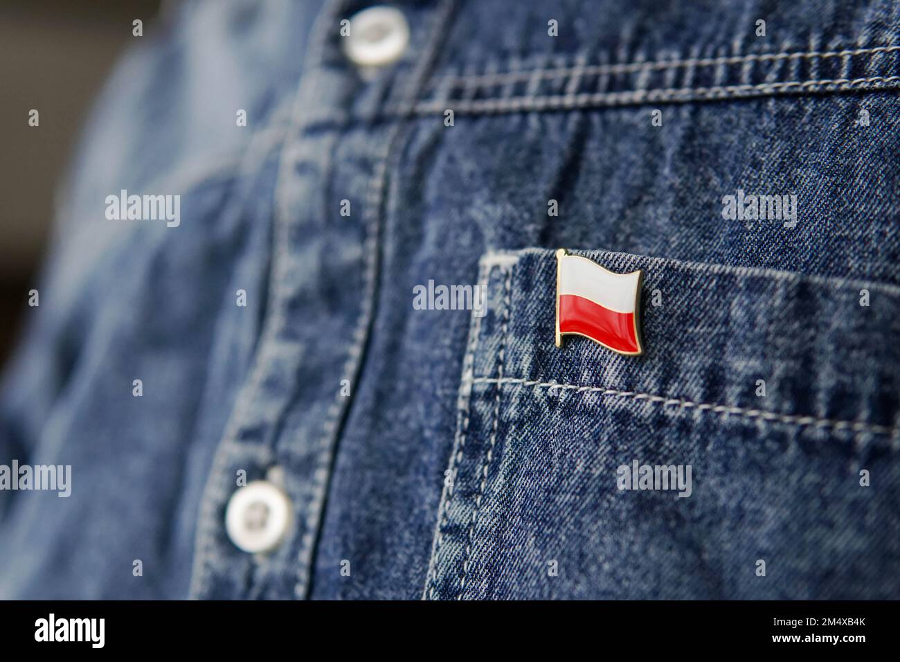 Metal badge with the flag of Poland is pinned on blue jeans jacket ...