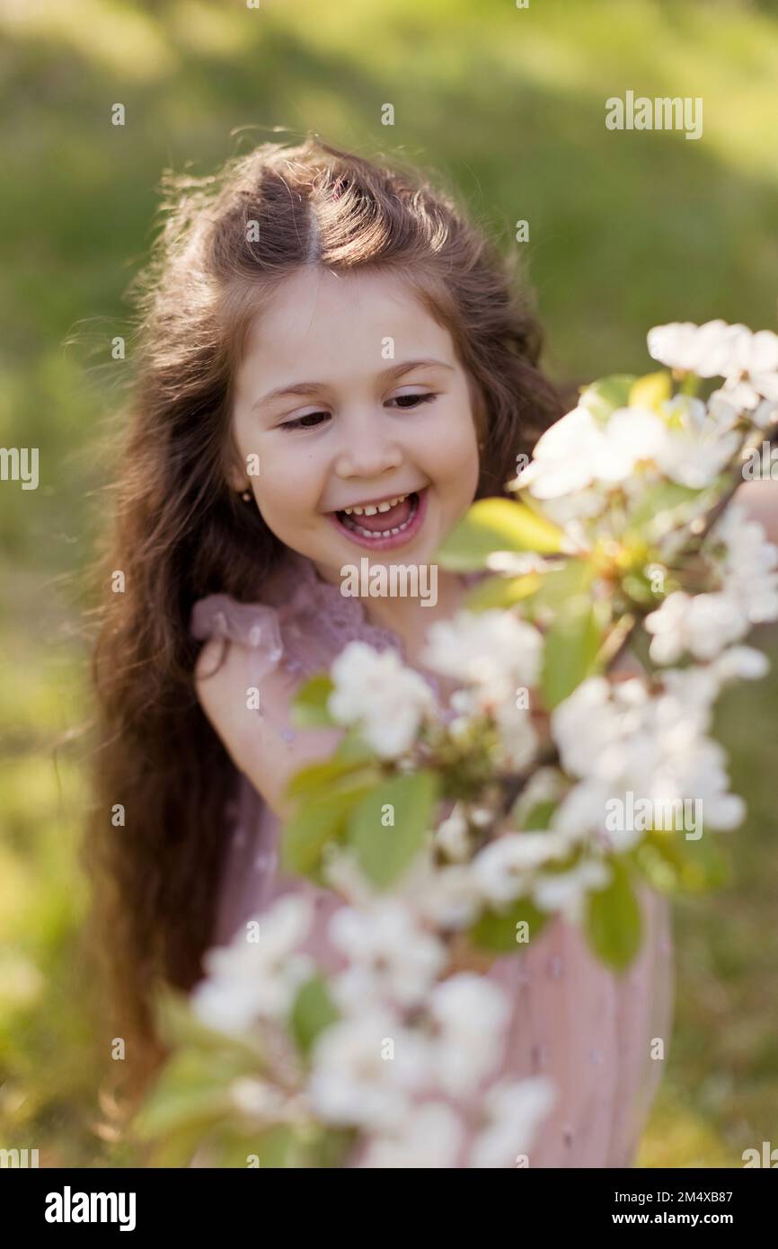 Happy cute girl plucking cherry blossom flowers in garden Stock Photo ...