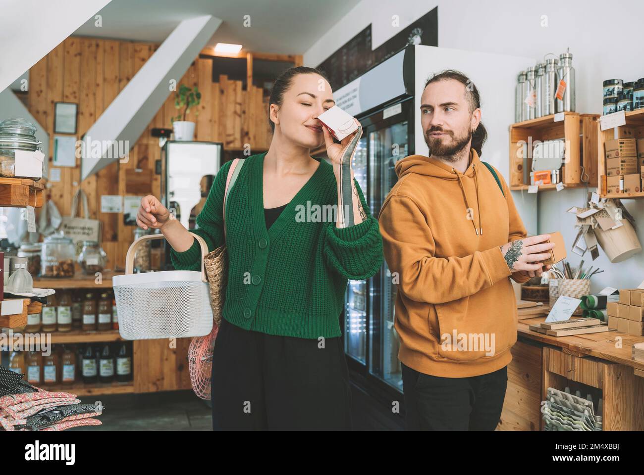Man looking at woman smelling soap in convenience store Stock Photo - Alamy