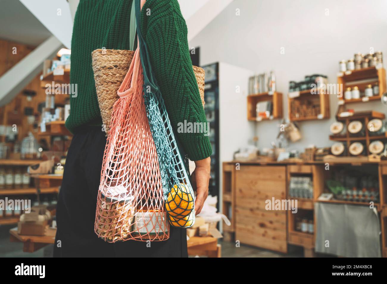 Customer carrying groceries in mesh bag at shop Stock Photo - Alamy