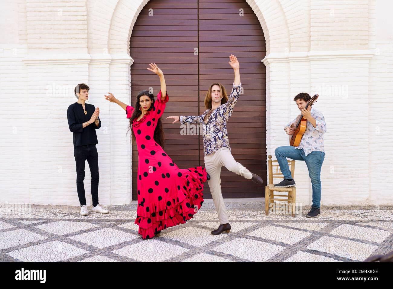 Flamenco dancers performing with guitarist in front of door Stock Photo ...