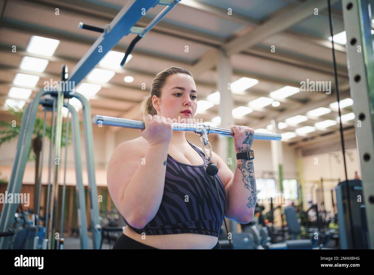 Overweight woman doing weight exercise in gym Stock Photo - Alamy