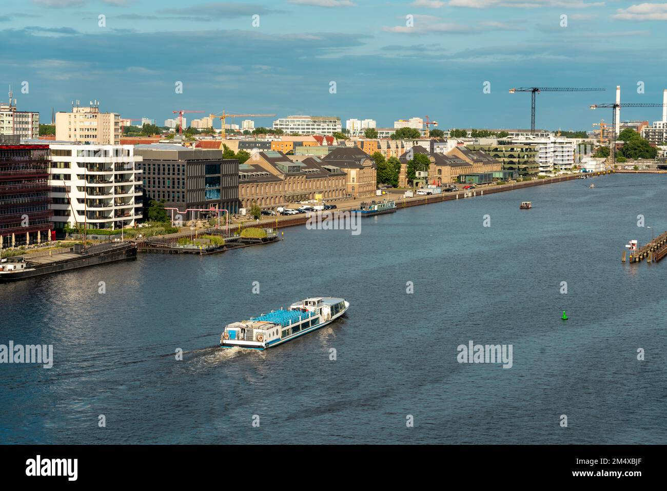 Germany, Berlin, Ferry sailing along river Spree with buildings of ...