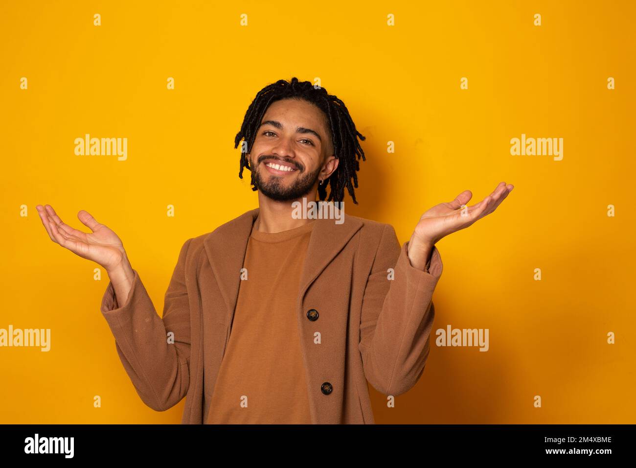 Happy man gesturing against yellow background Stock Photo - Alamy