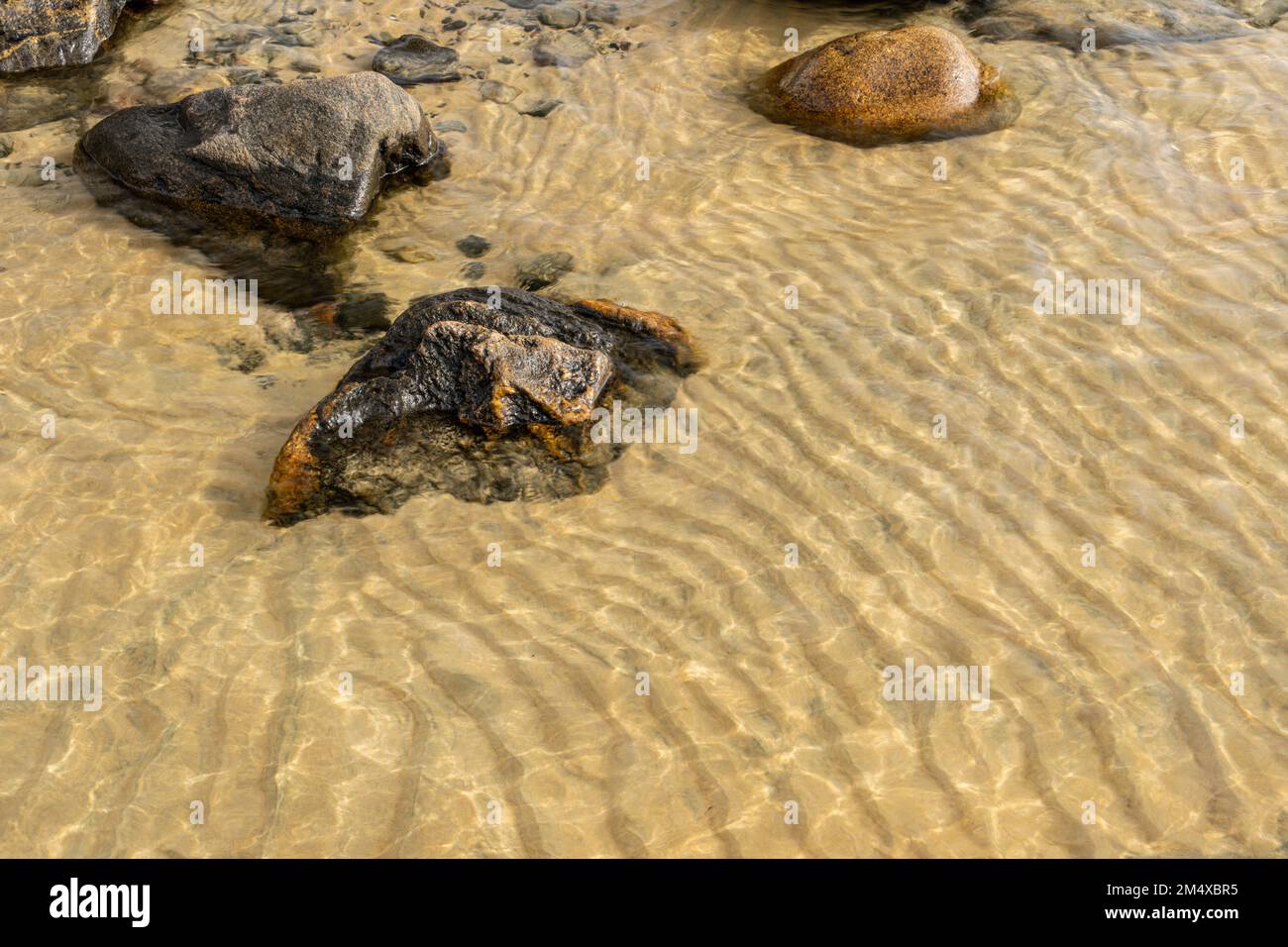Shoreline rocks, sand ripples and shallow water, Lake Superior ...