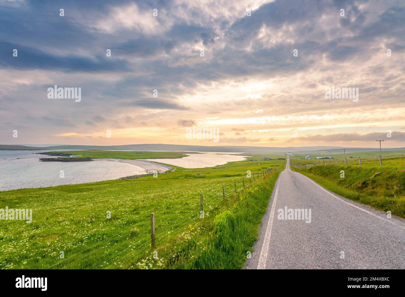 UK, Scotland, Yell, Clouds over empty asphalt road with Loch of ...