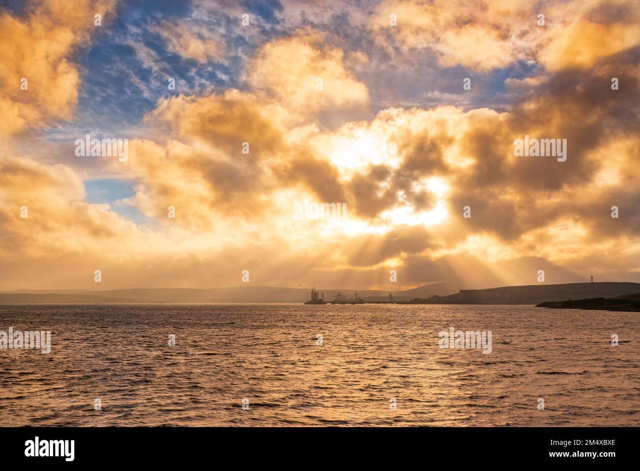 UK, Scotland, Dramatic sunset over Sullom Voe with oil terminal and gas ...