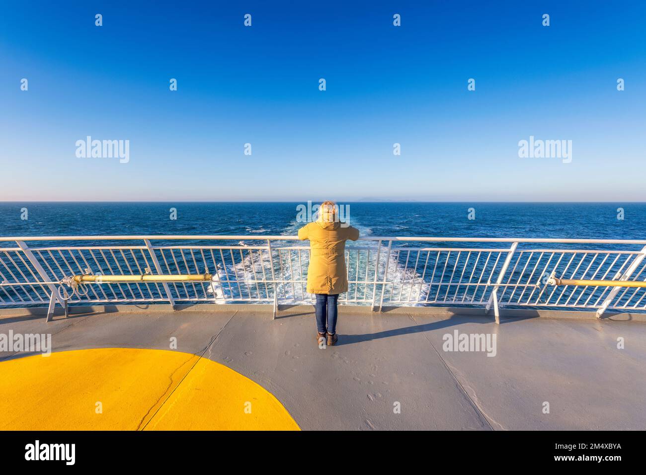 UK, Scotland, Lone woman standing on afterdeck of moving ferry Stock ...
