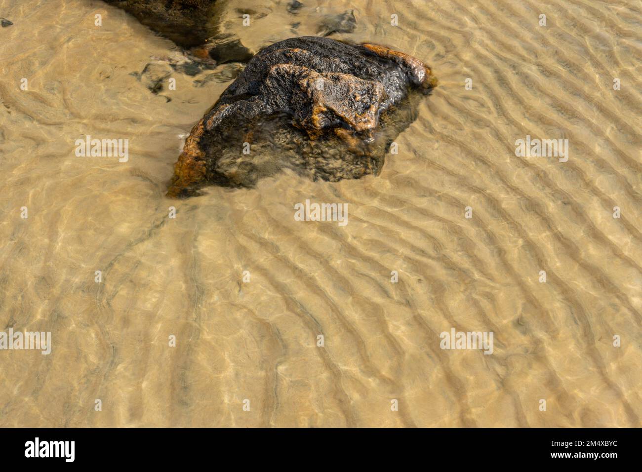 Shoreline rocks, sand ripples and shallow water, Lake Superior ...