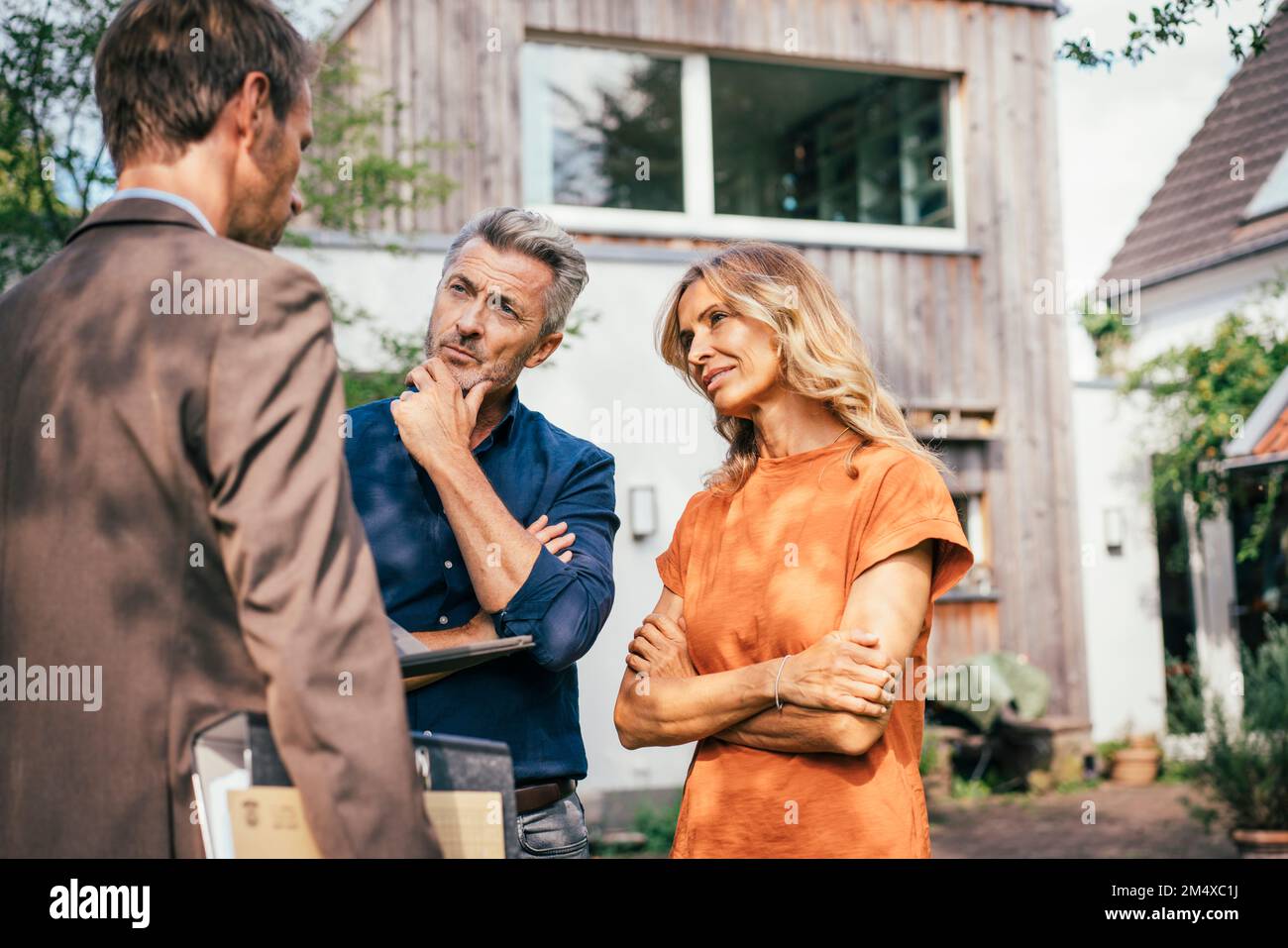 Mature couple having discussion with real estate agent Stock Photo - Alamy