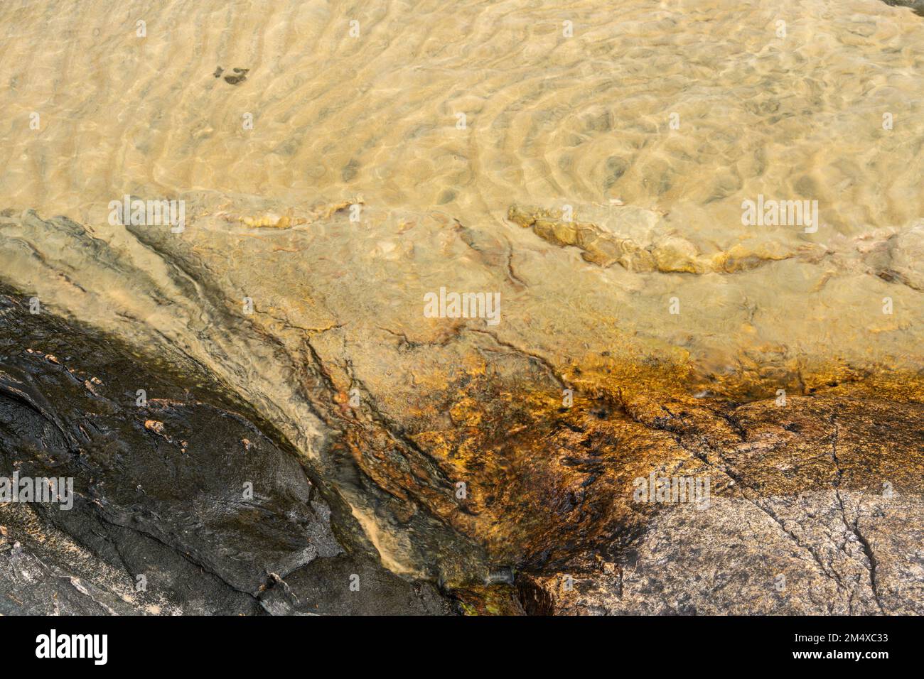 Shoreline rocks, sand ripples and shallow water, Lake Superior ...