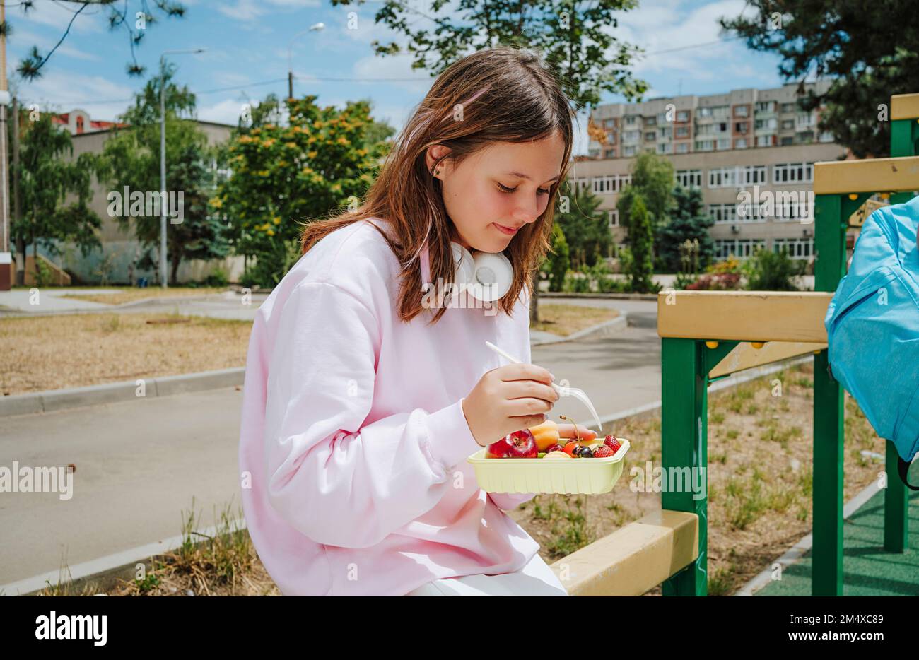 Girl eating food from lunch box on sunny day Stock Photo - Alamy