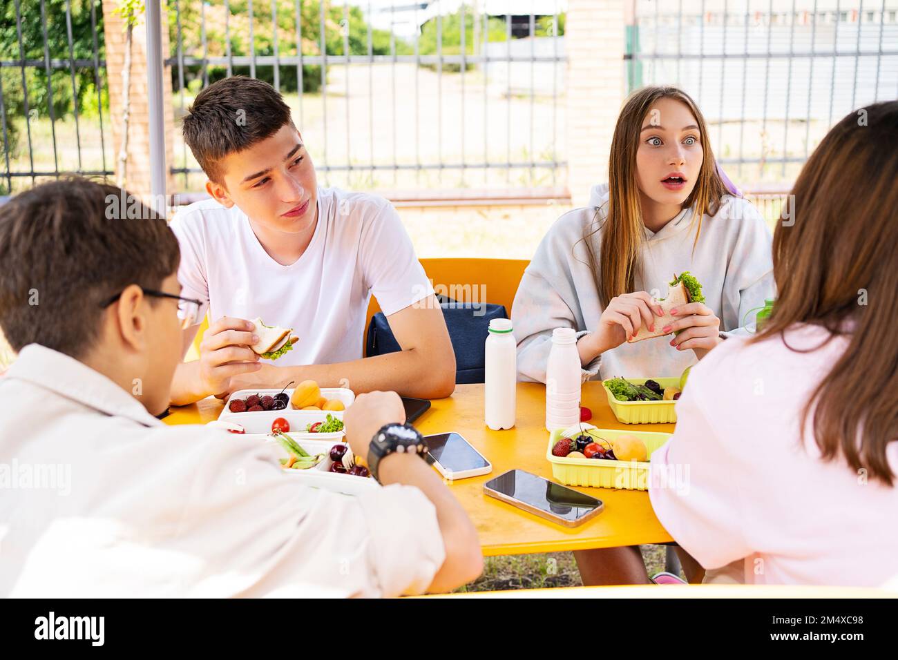 Shocked girl sitting with friends having lunch Stock Photo - Alamy