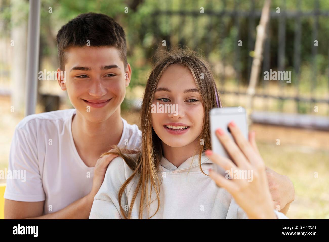 Teenage girl taking selfie with boy outdoors Stock Photo - Alamy