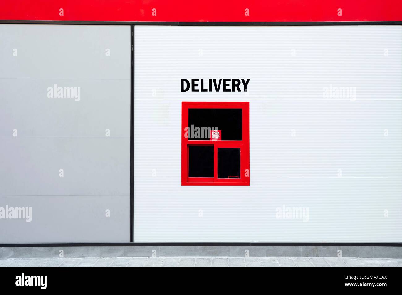 Delivery written above red window on wall Stock Photo - Alamy