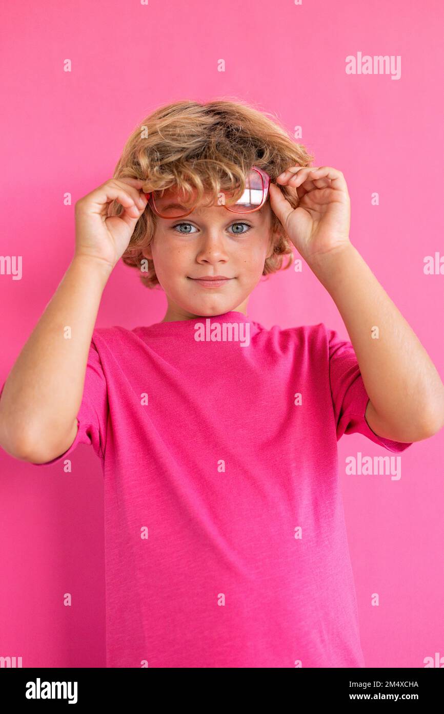 Boy wearing pink t-shirt against colored background Stock Photo - Alamy