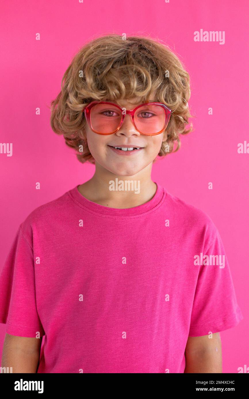 Smiling boy wearing colored sunglasses against pink background Stock ...