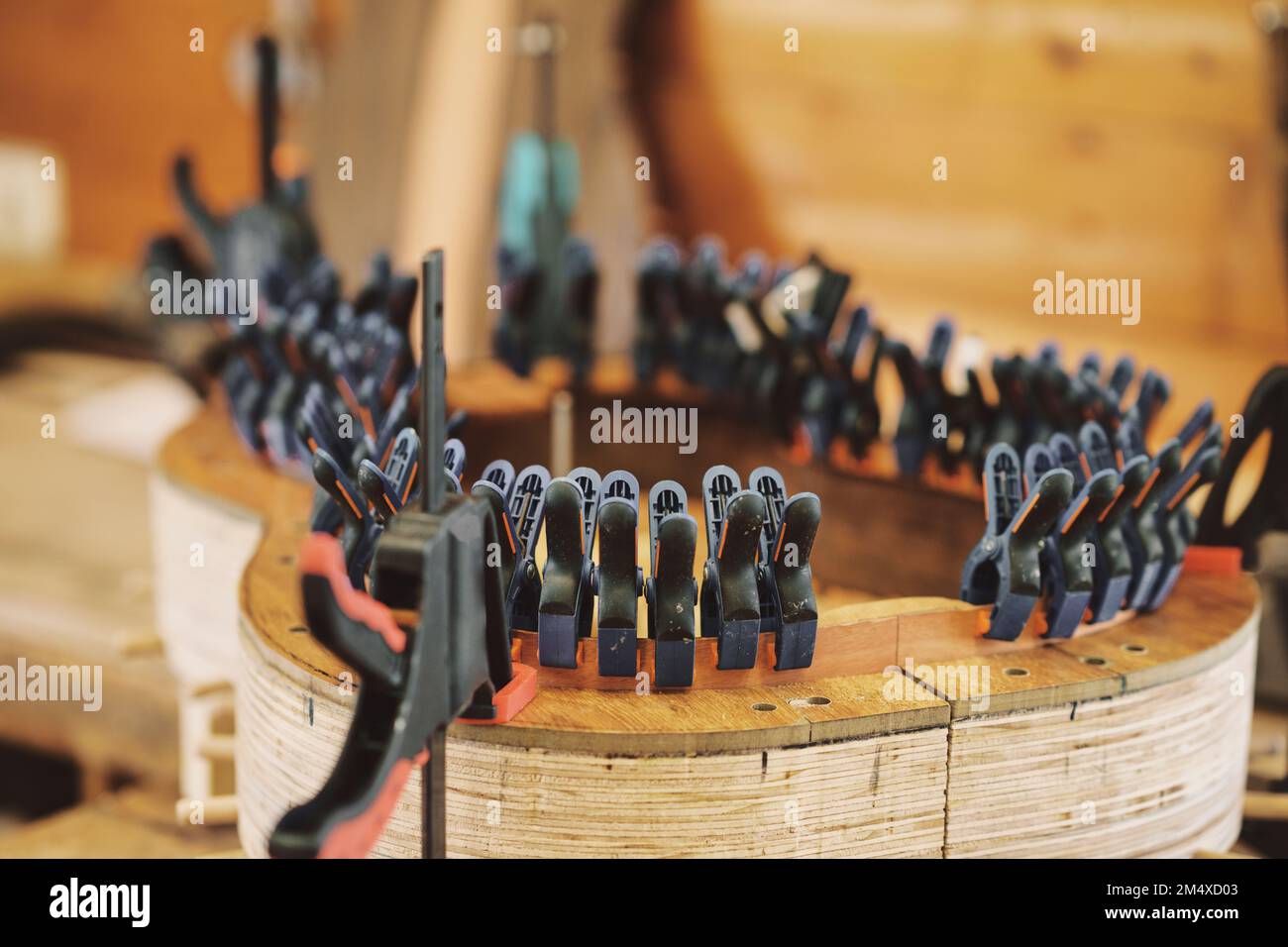 Cramps shaping wood for guitar on workbench at workshop Stock Photo - Alamy