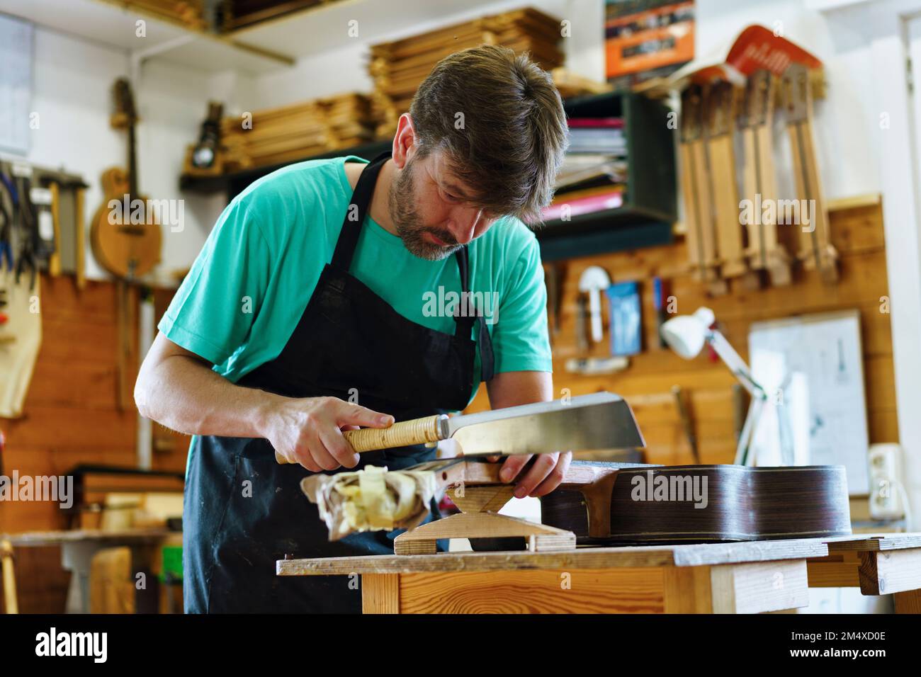 Luthier cutting fretboard on workbench in workshop Stock Photo - Alamy