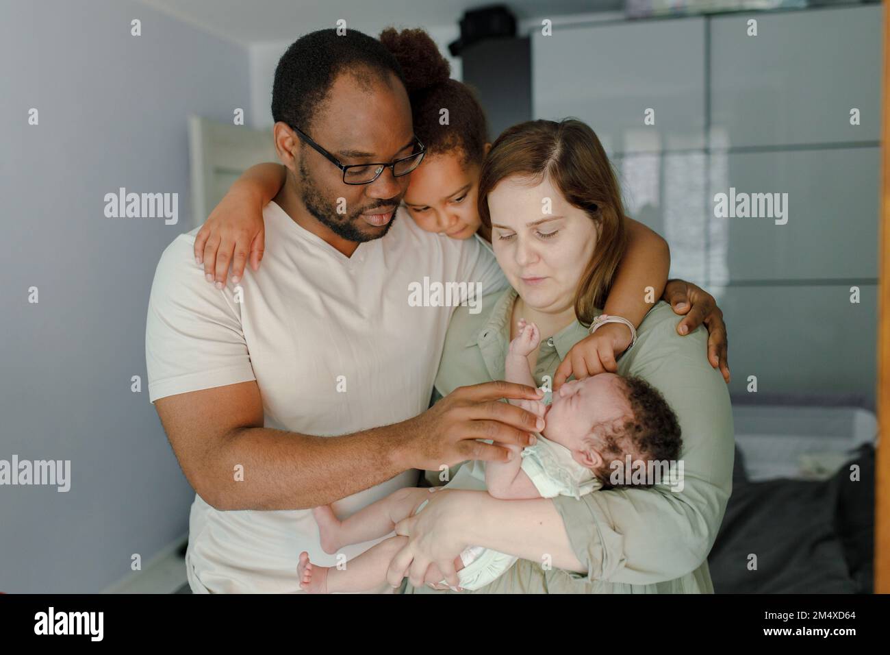 Family pampering crying baby girl at home Stock Photo - Alamy