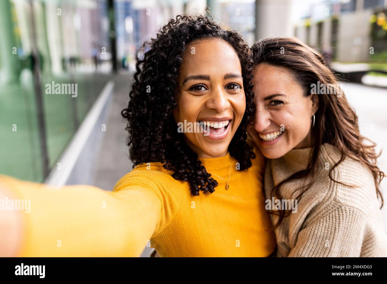 Happy woman taking selfie with friend Stock Photo - Alamy
