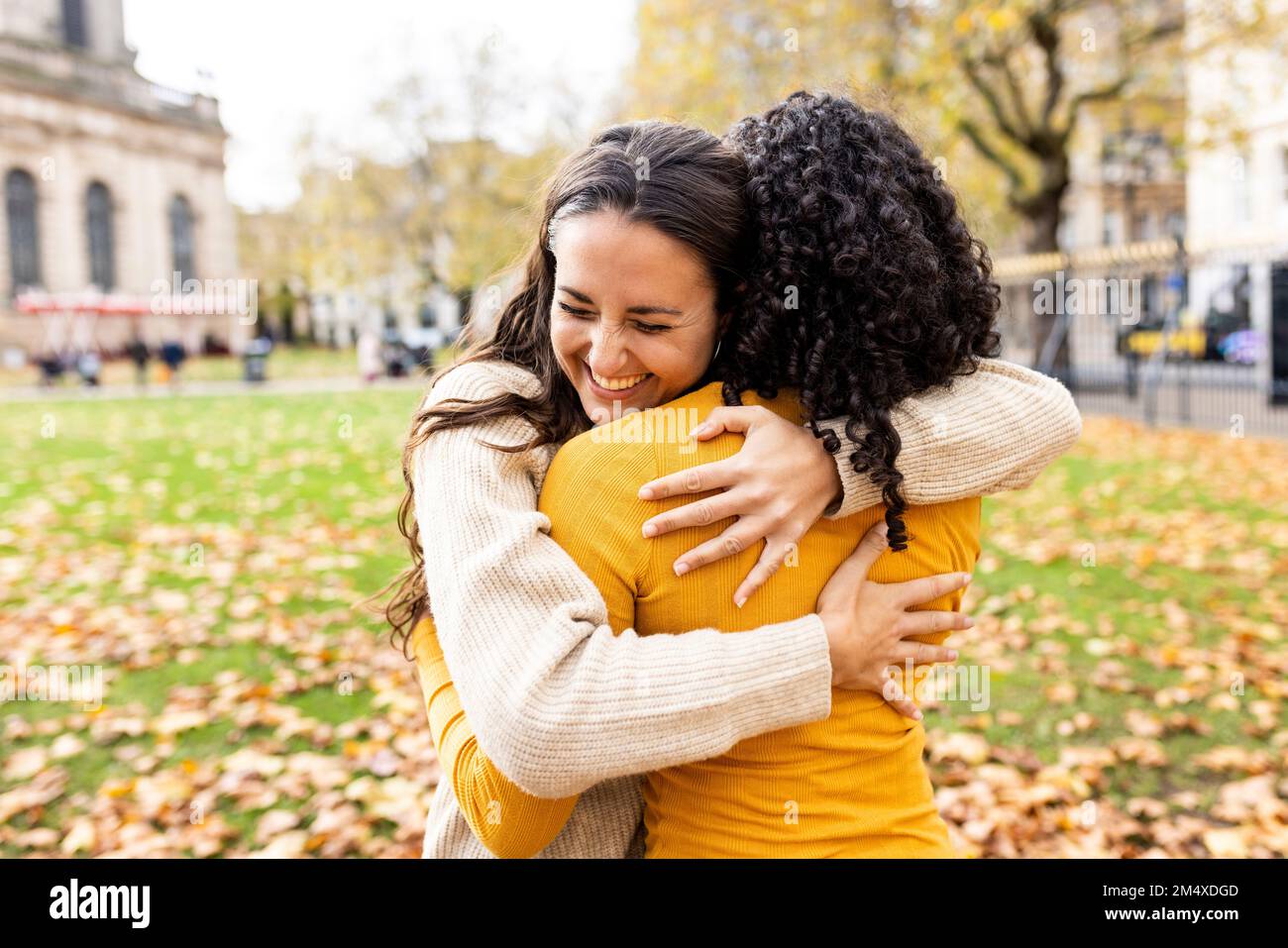 Woman hugging friend at autumn park Stock Photo - Alamy