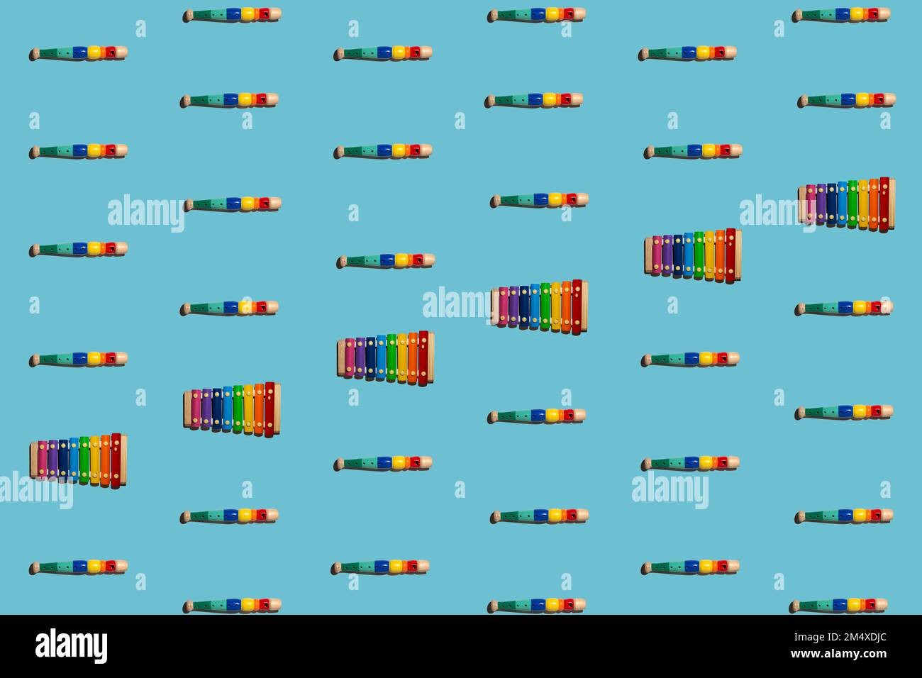 Pattern of colorful flutes and xylophones flat laid against blue ...