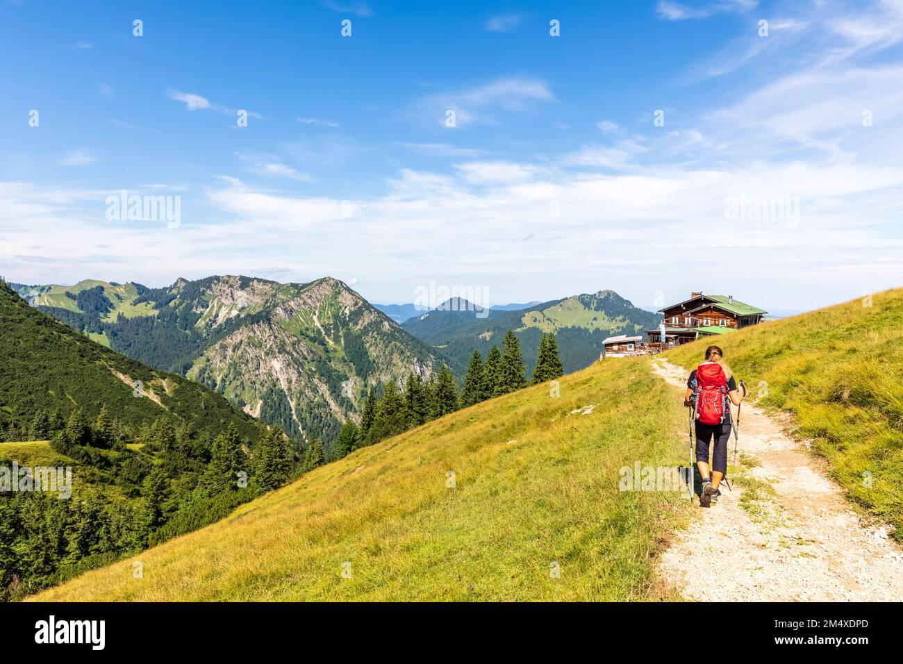 Germany, Bavaria, Female hiker following trail leading to alpine huts ...