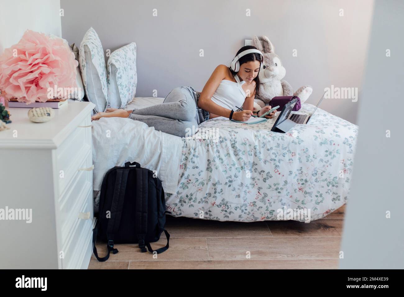 Girl using smart phone studying in bedroom at home Stock Photo - Alamy