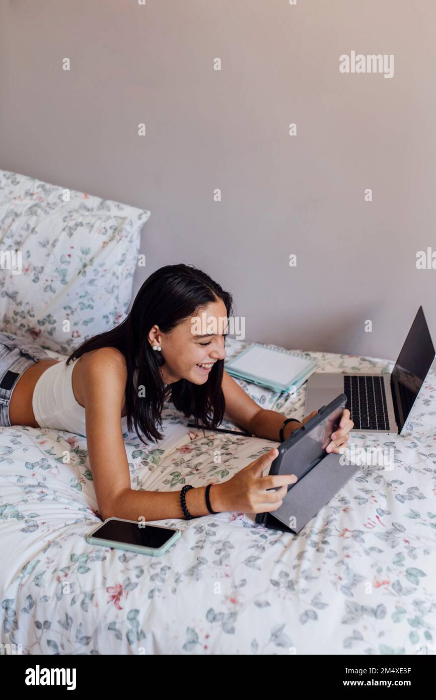 Girl lying on bed using smartphone laptop hi-res stock photography and ...