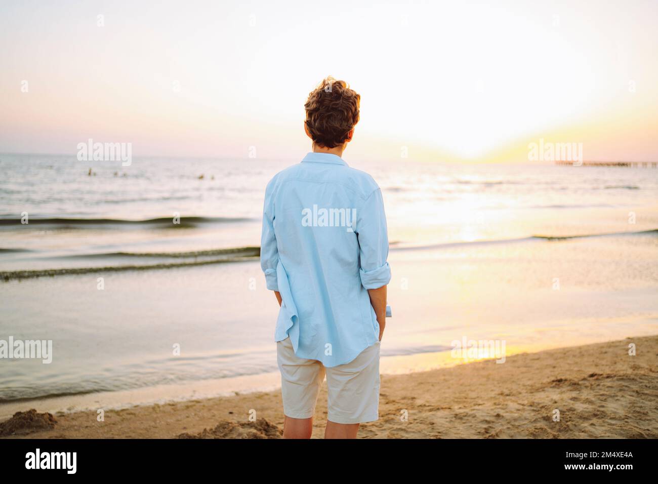 Woman on beach looking at sea Stock Photo - Alamy