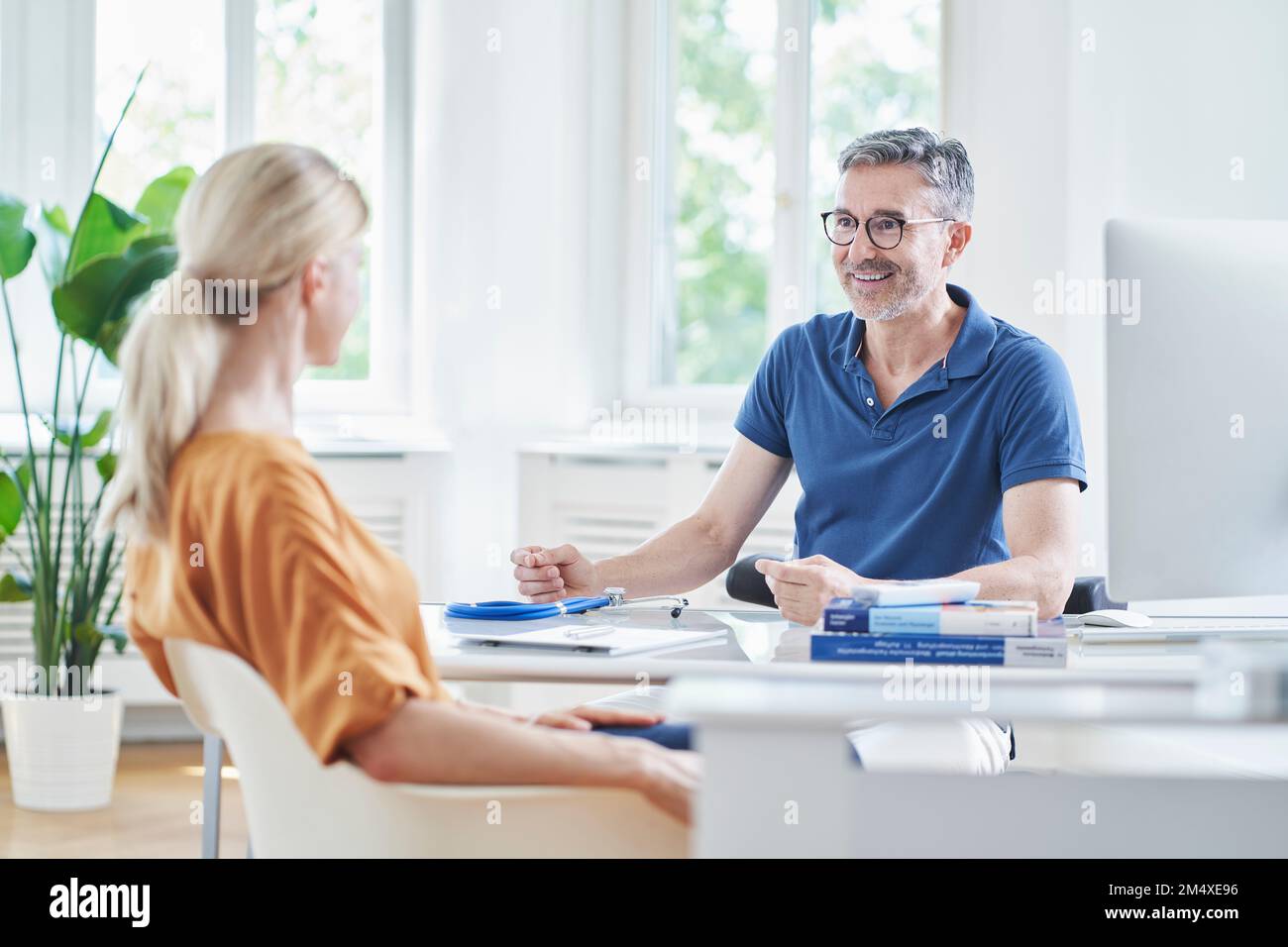 Patient having discussion with doctor at medical practice Stock Photo ...