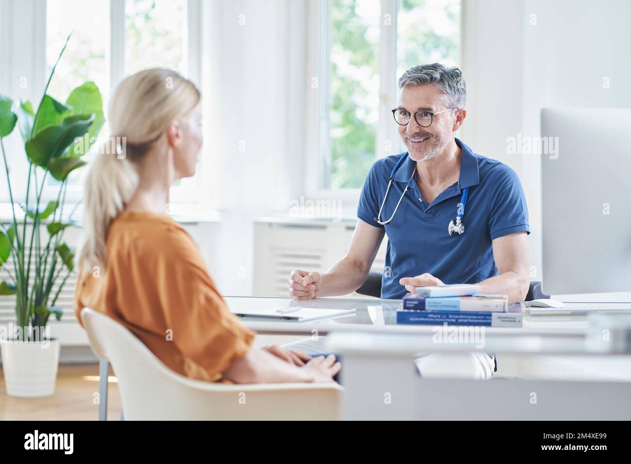 Happy doctor having discussion with patient at medical practice Stock ...