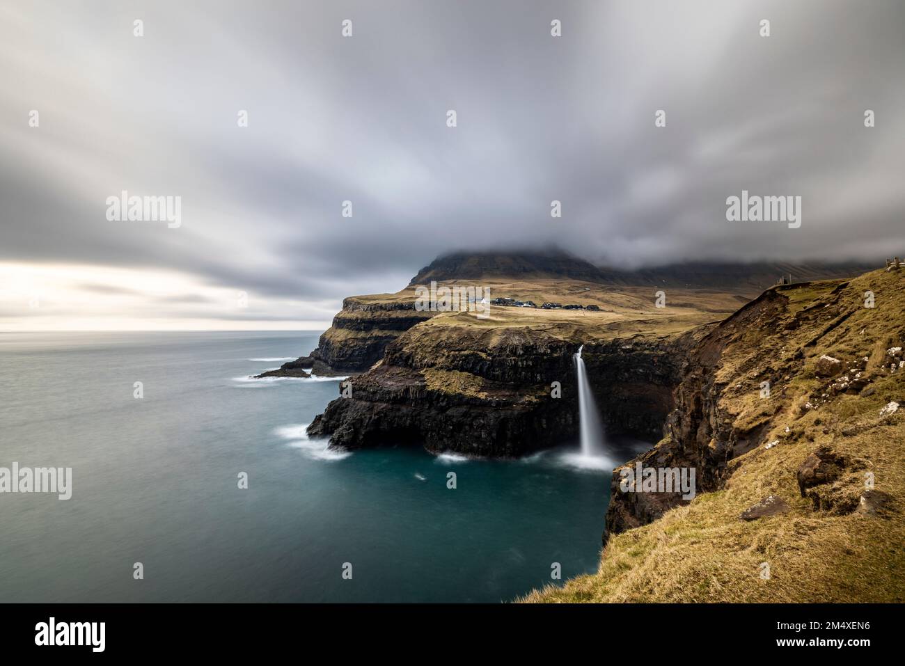 Scenic view of Mulafossur waterfall under cloudy sky Stock Photo - Alamy