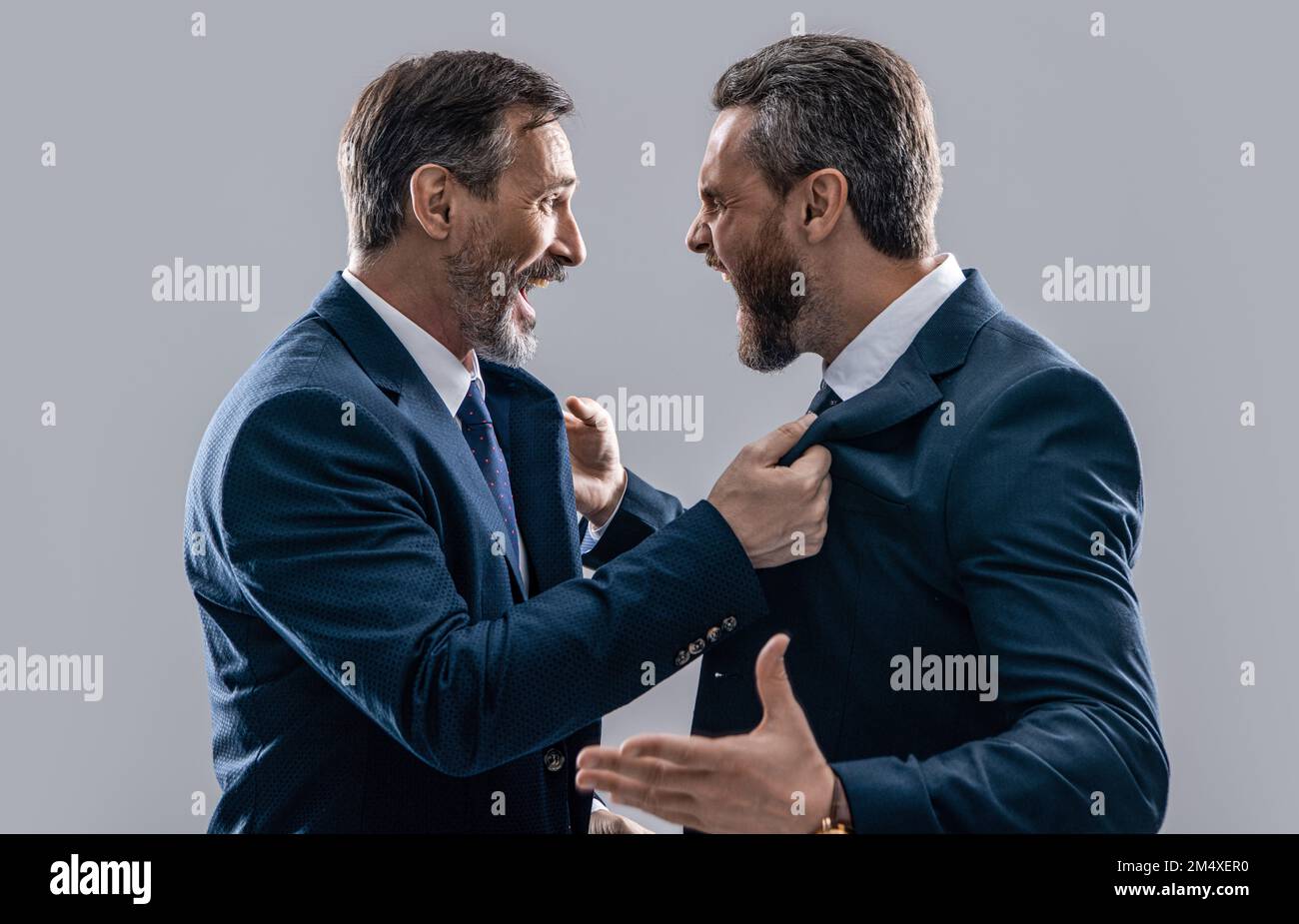 two arguing businessmen shout in conflict isolated on grey background ...