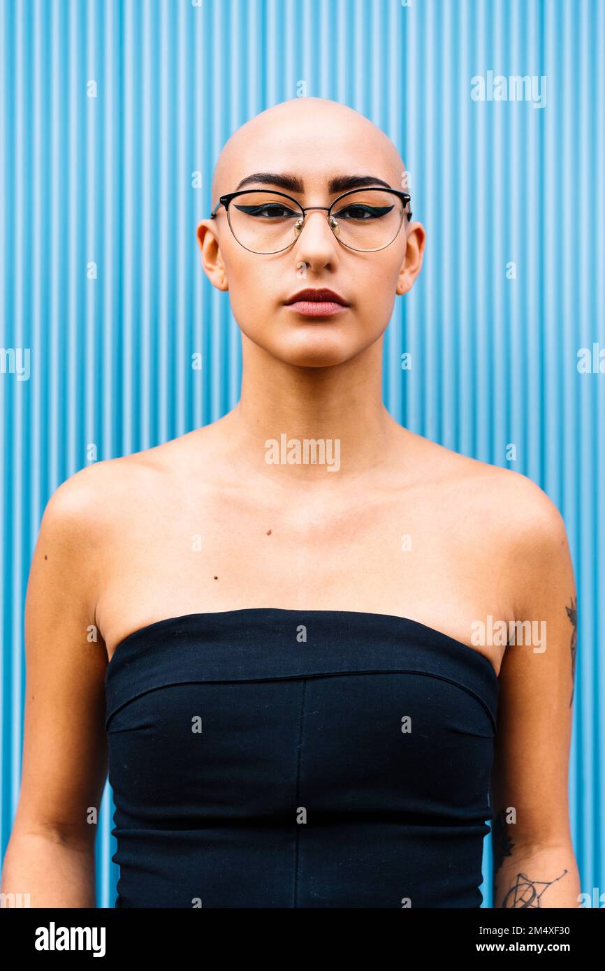 Confident Young Woman With Shaved Head Wearing Eyeglasses In Front Of