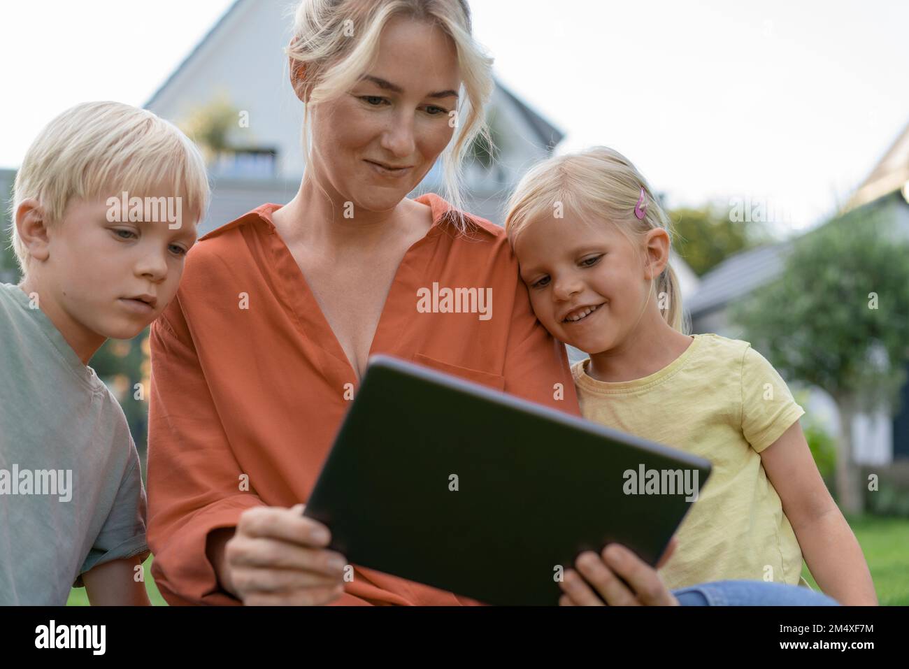 Smiling woman showing tablet PC to children Stock Photo - Alamy