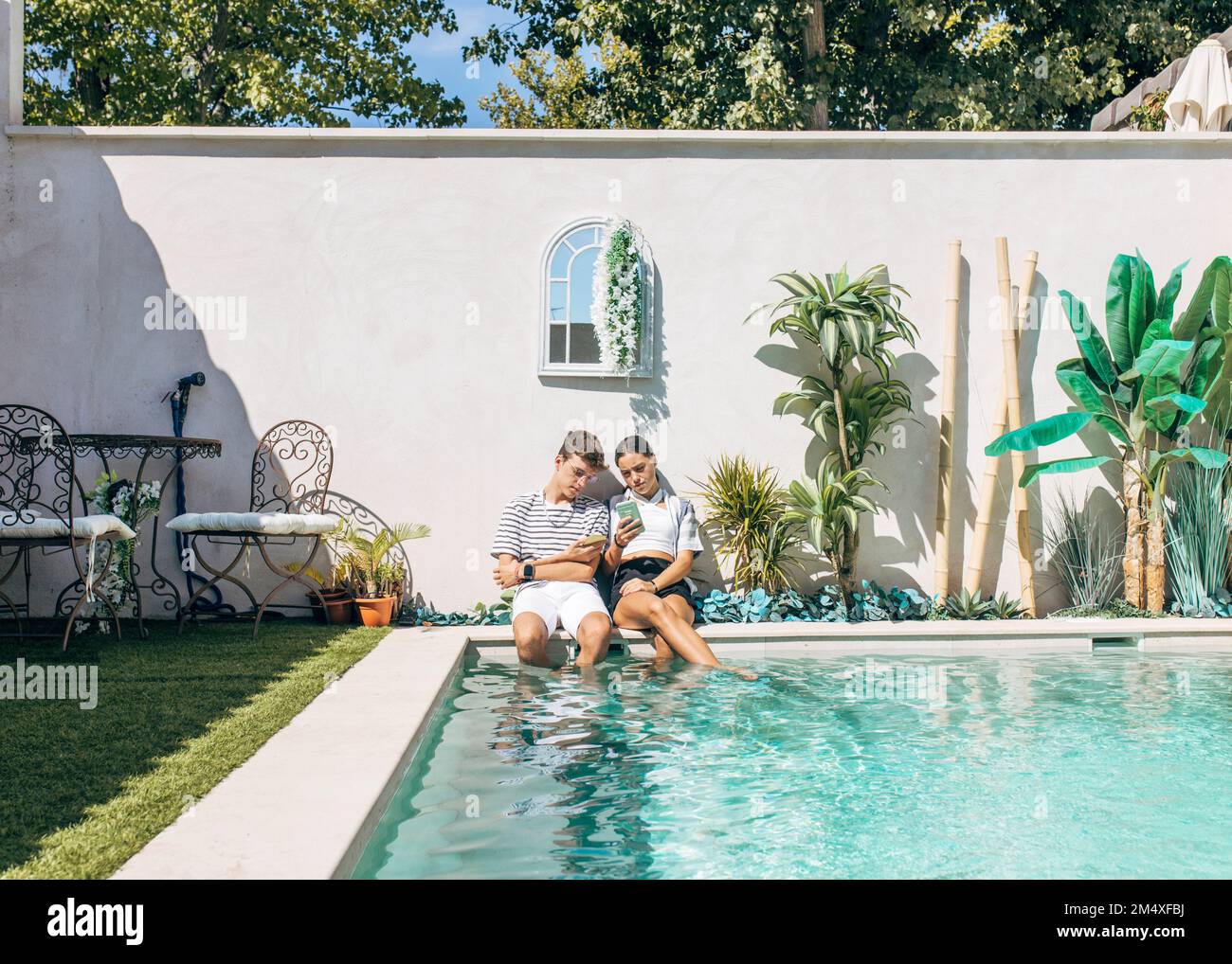 Family sitting swimming pool hi-res stock photography and images - Alamy