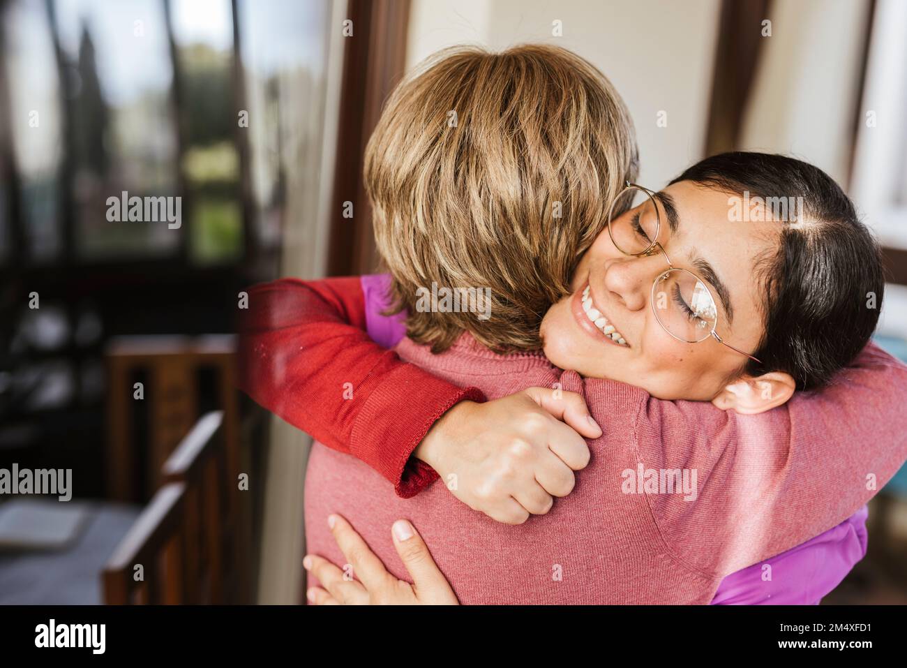 Happy caregiver hugging senior woman at home Stock Photo - Alamy